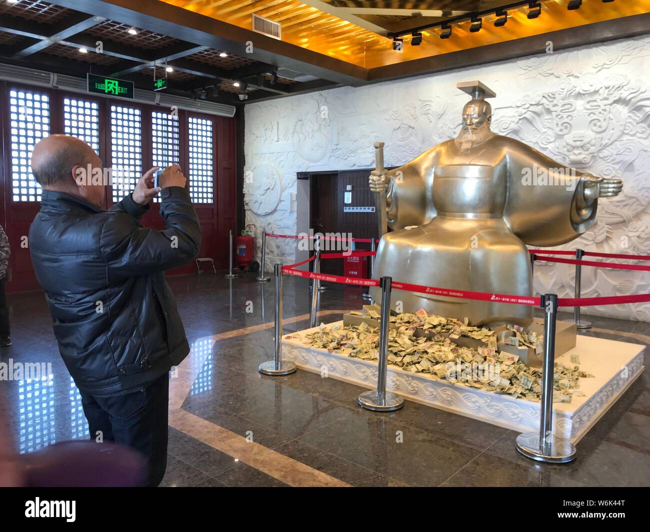 A tourist takes photos of a statue of the Yellow Emperor, also known as ...