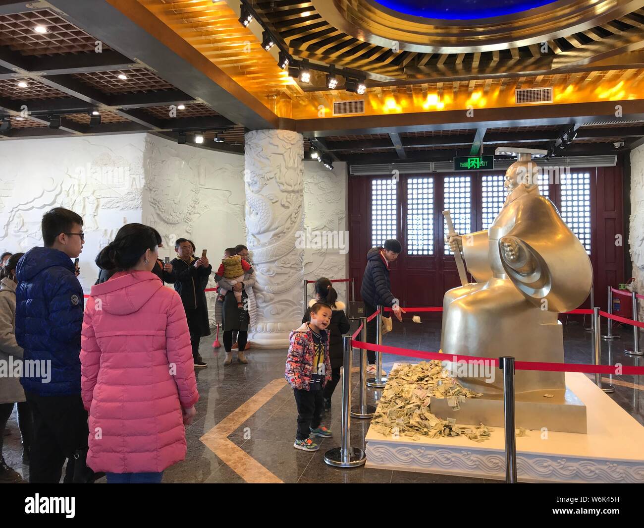 Local residents and tourists look at a statue of the Yellow Emperor ...