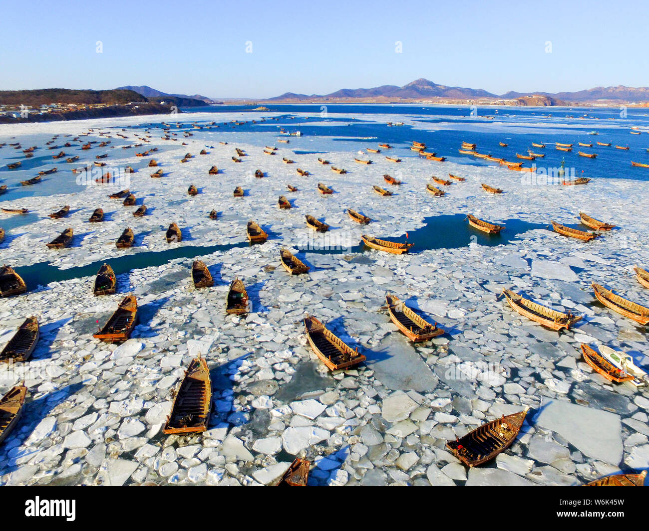Aerial view of massive fishing ships and boats trapped on the frozen ...