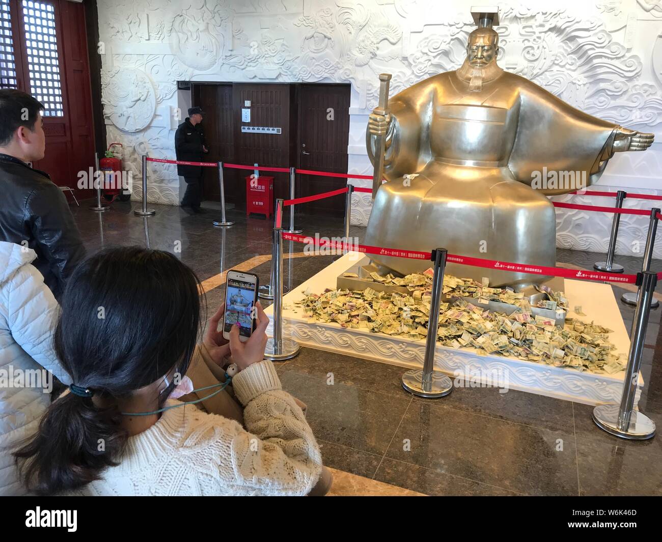 A tourist takes photos of a statue of the Yellow Emperor, also known as ...