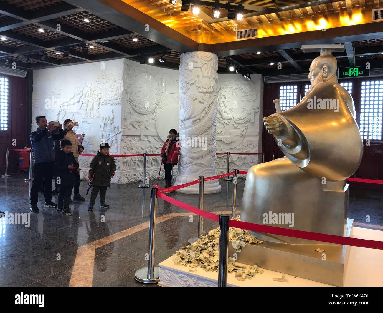 Local residents and tourists look at a statue of the Yellow Emperor ...