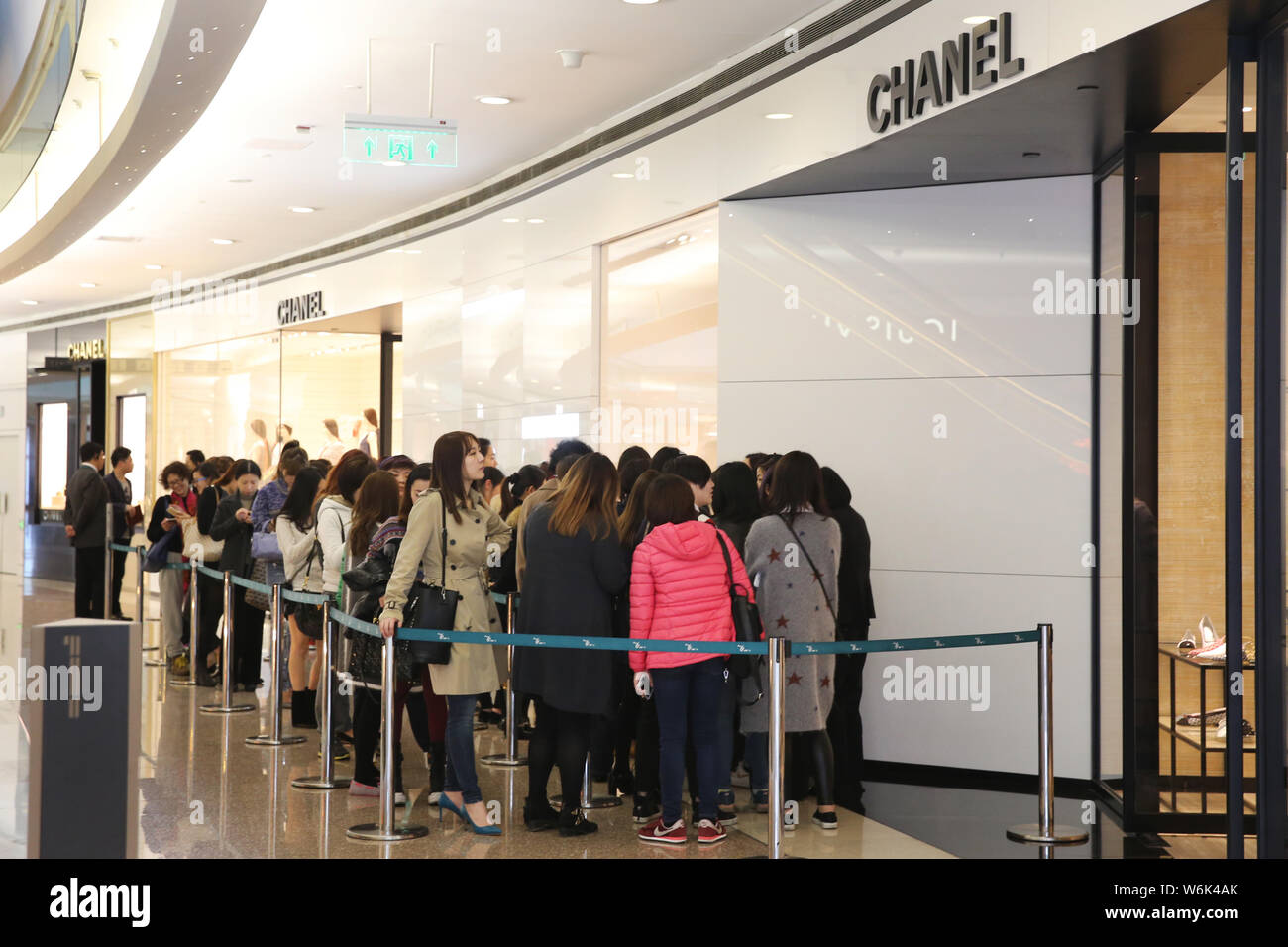 --FILE--Chinese customers wait in a long queue in front of the fashion ...