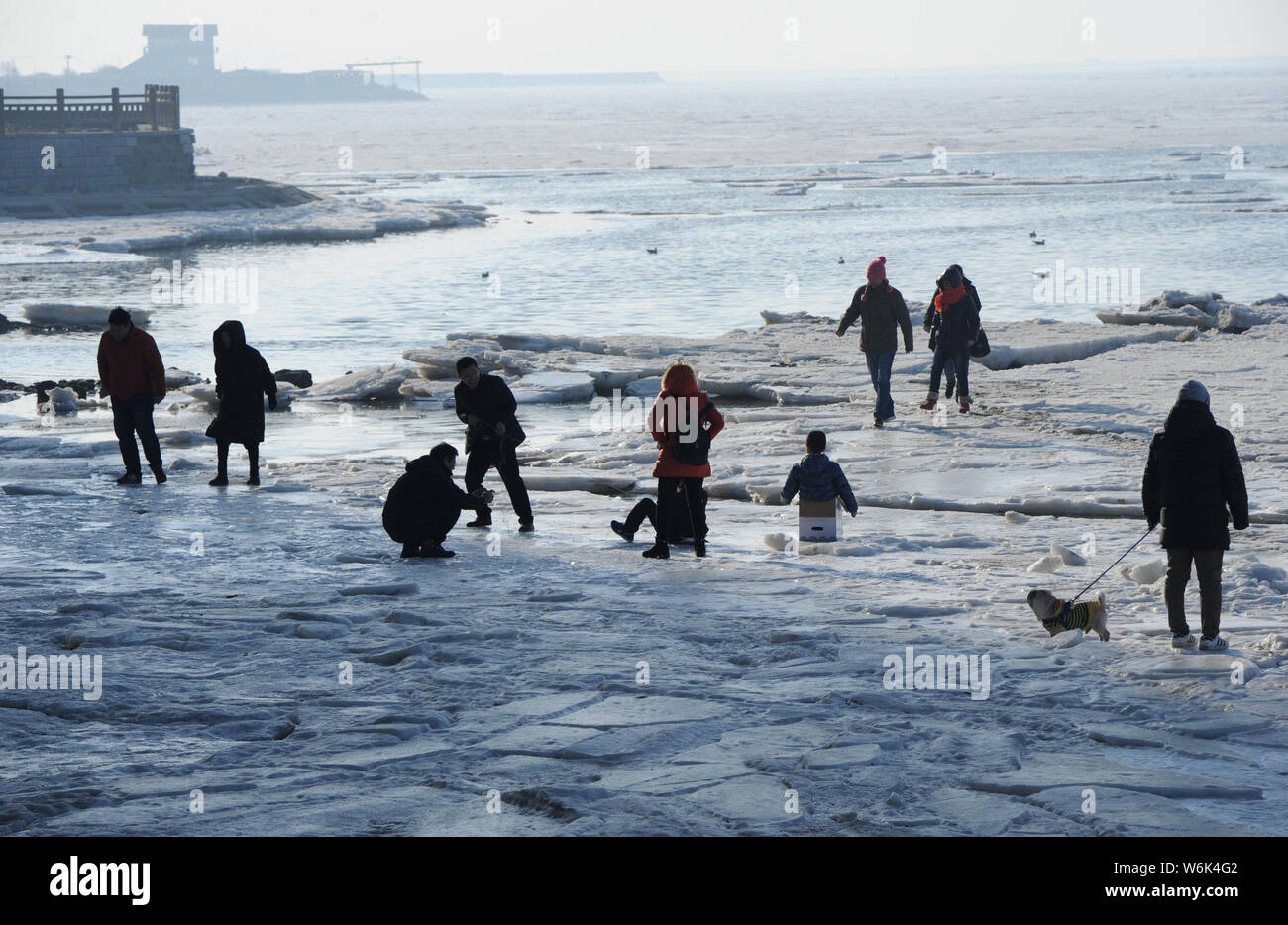 Tourists enjoy themselves on the floating melted sea ice at the Bohai ...