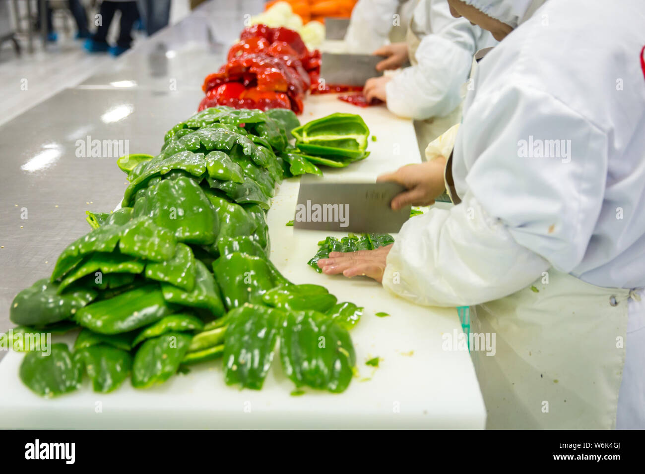 Chinese workers cut up vegetables at a food processing plant of Beijing ...