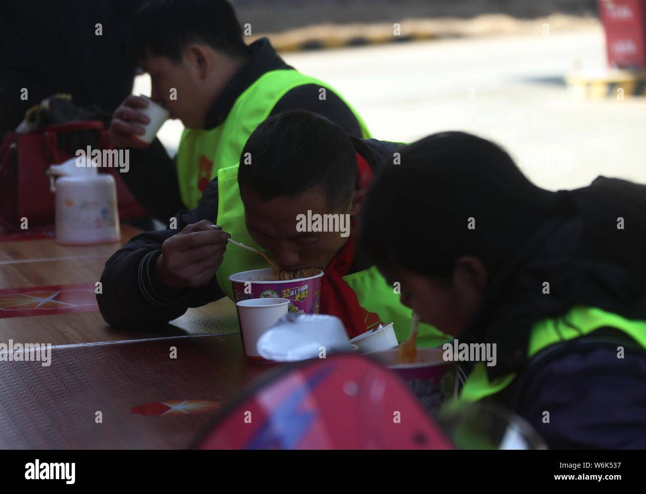 Chinese migrant workers eat instant noodles at a gas station of CNPC ...