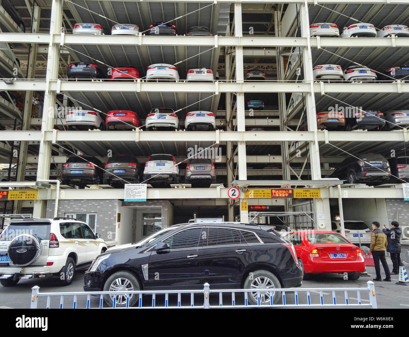 Chinese drivers queue up to park their cars in an automated stacked ...