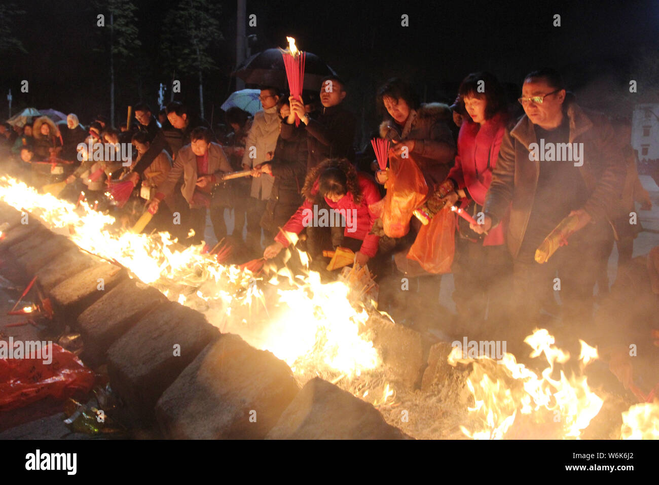 Chinese worshippers burn incense sticks to pray for wealth and ...