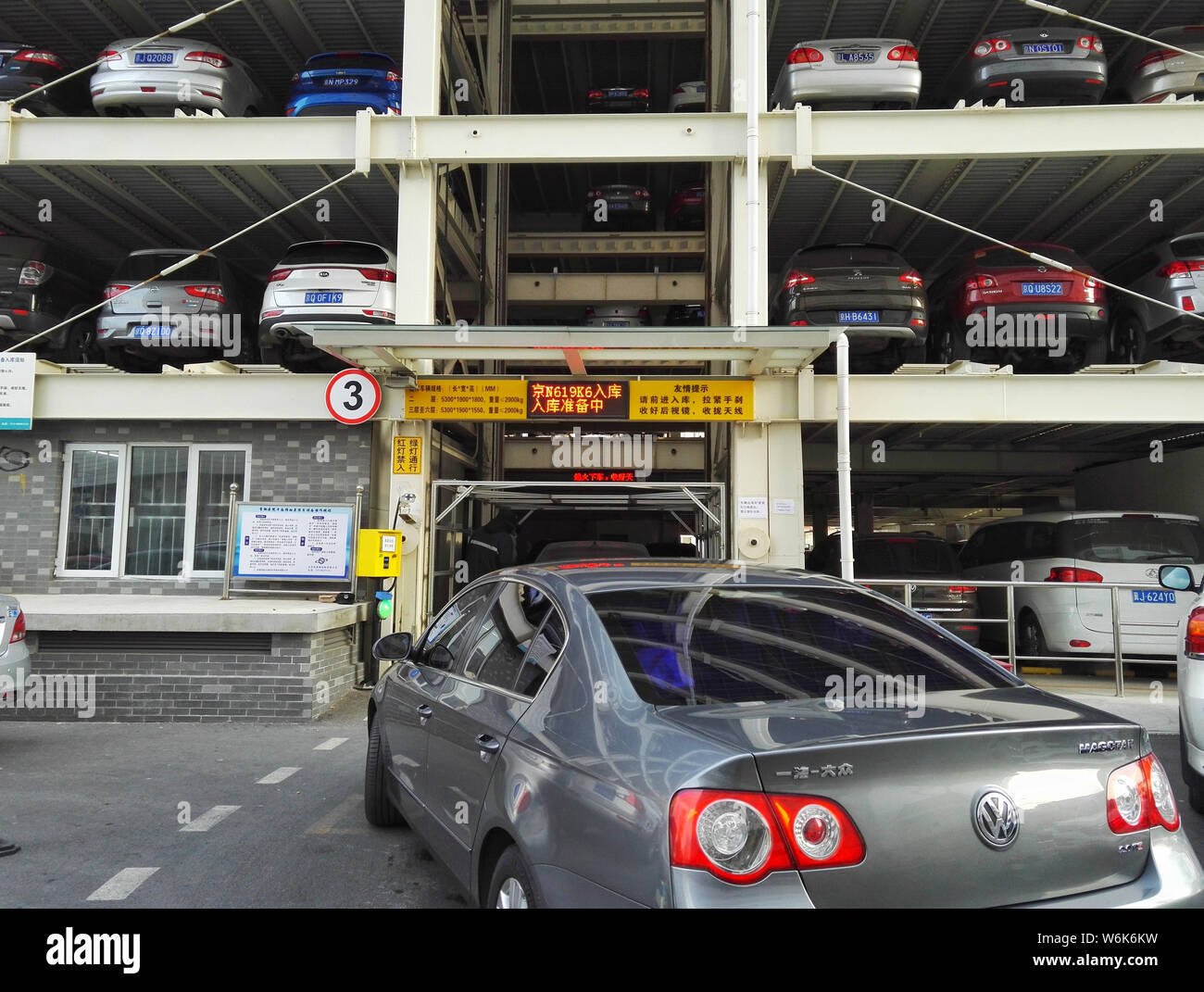 Chinese drivers queue up to park their cars in an automated stacked ...