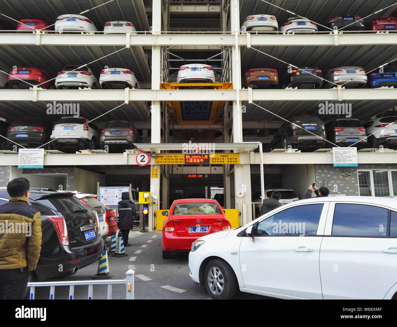 Chinese drivers queue up to park their cars in an automated stacked ...