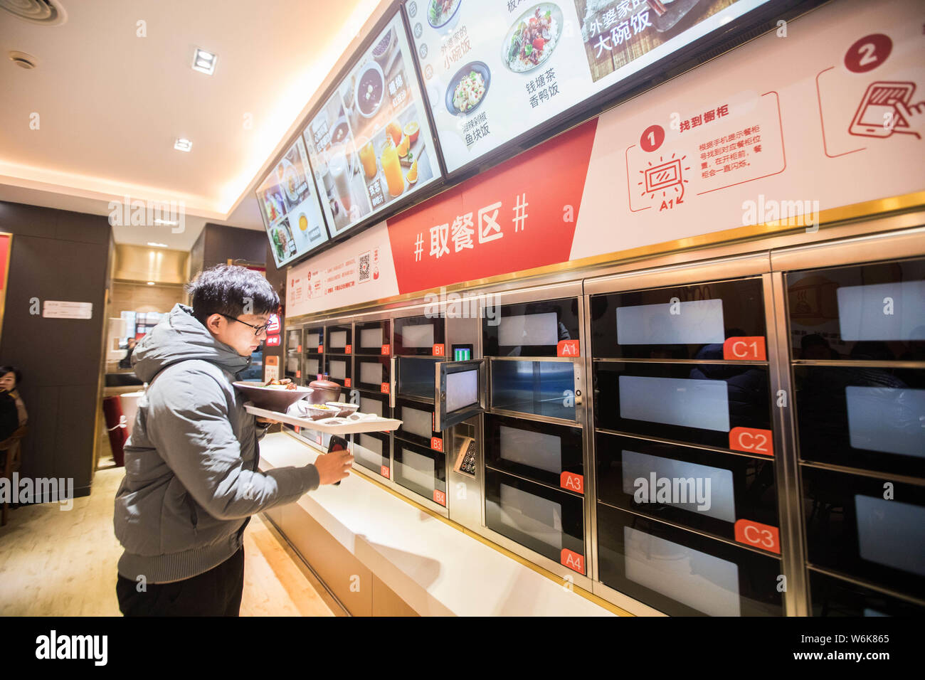 A customer gets his food from the food pick-up window at the first ...