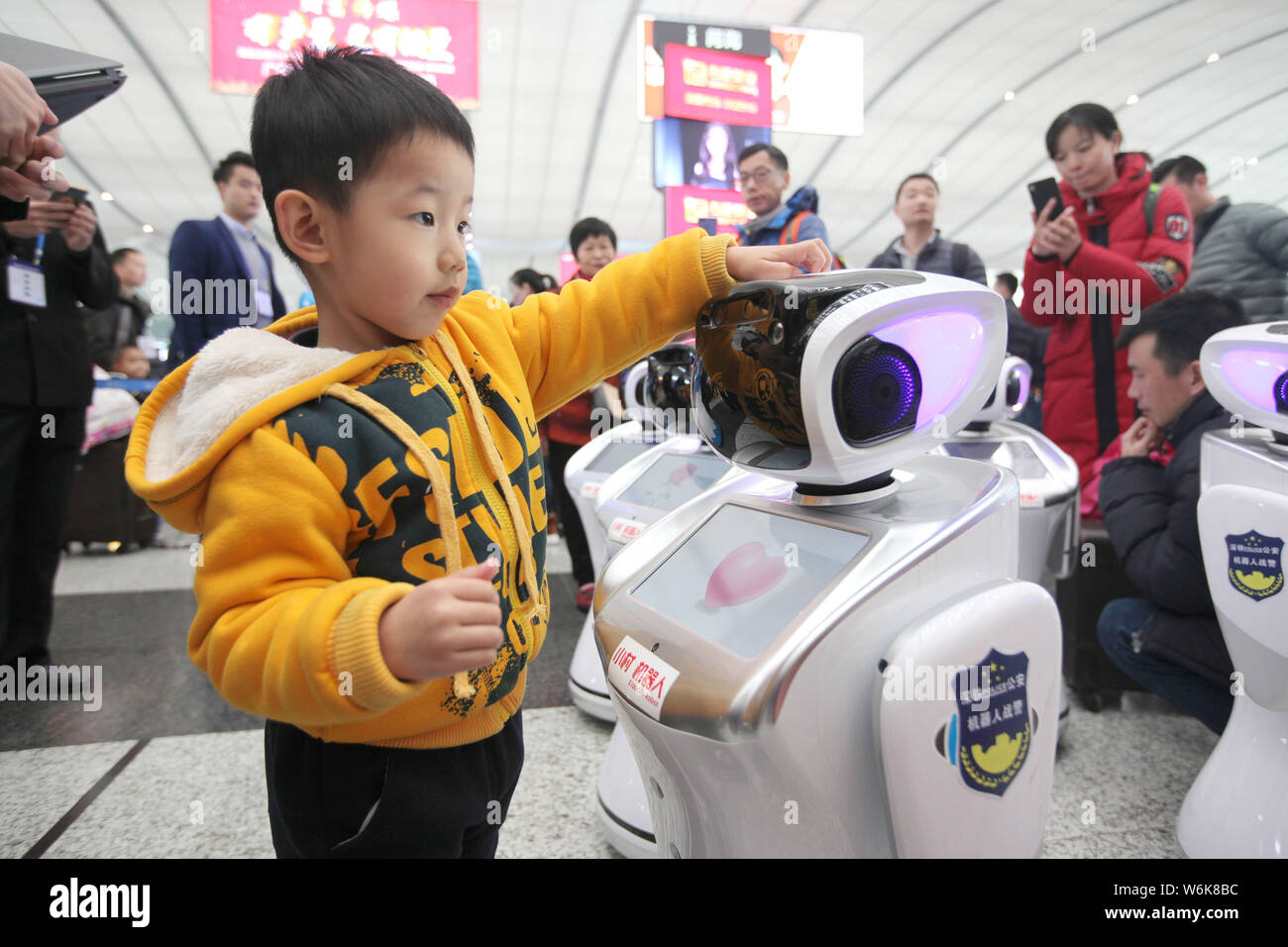 A child interacts with automated police robots, or "robocops" with ...
