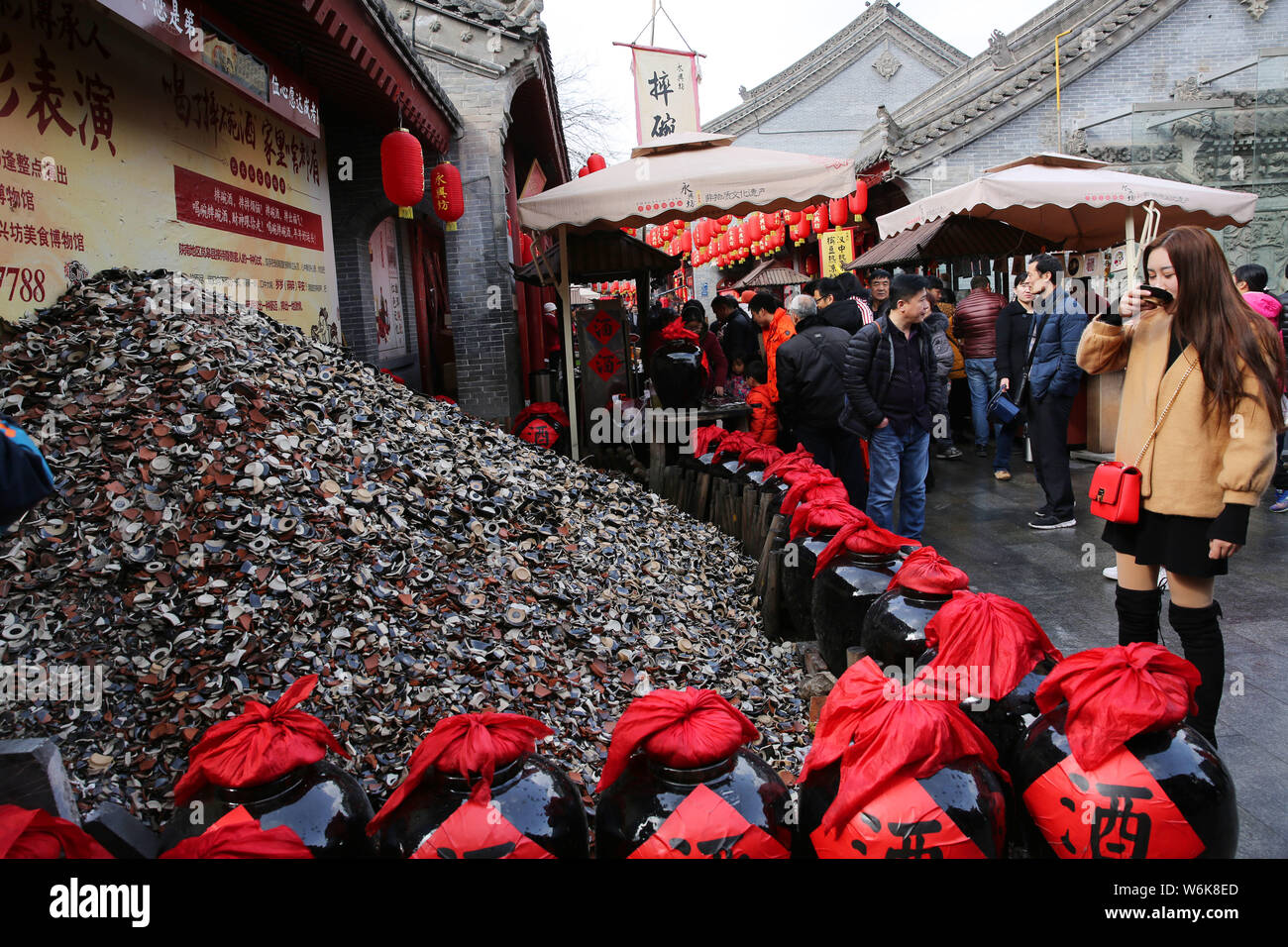 A tourist drinks a bowl of rice wine during the Chinese Lunar New Year ...
