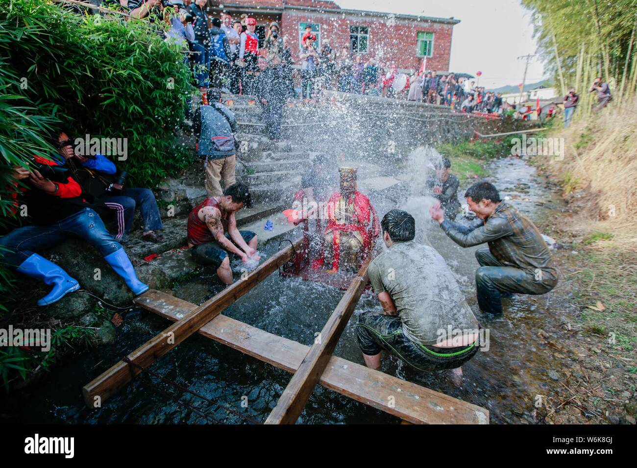 Chinese villagers of the Hakka people carry a golden statue of ancient ...