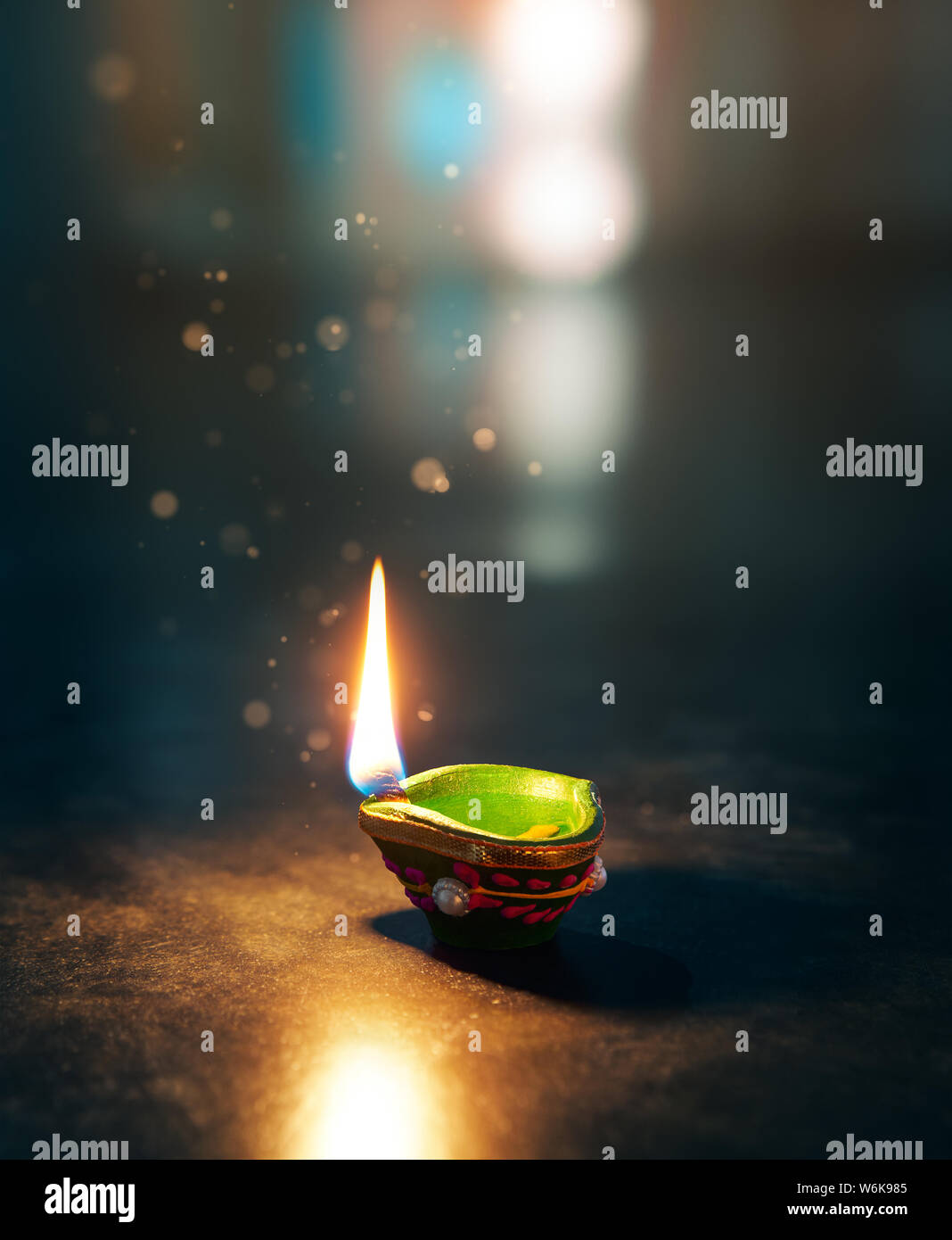 Happy Diwali - Lit diya lamp on an abtract background with shallow ...