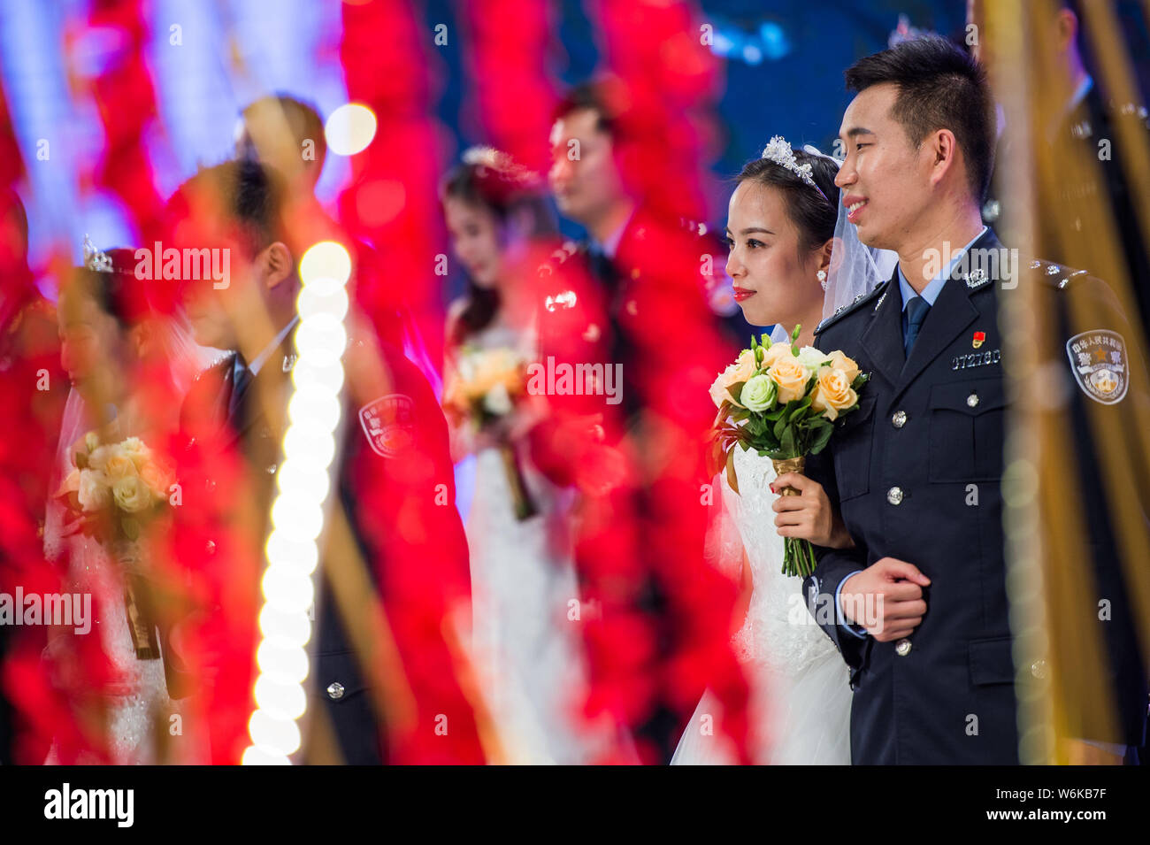 Police couples take part in a group wedding ceremony in Shenzhen city ...