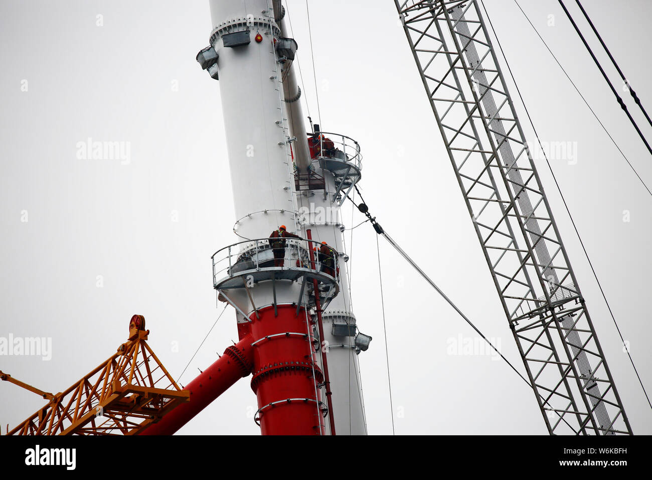 Workers labour on the world's highest electricity pylon, also known as ...