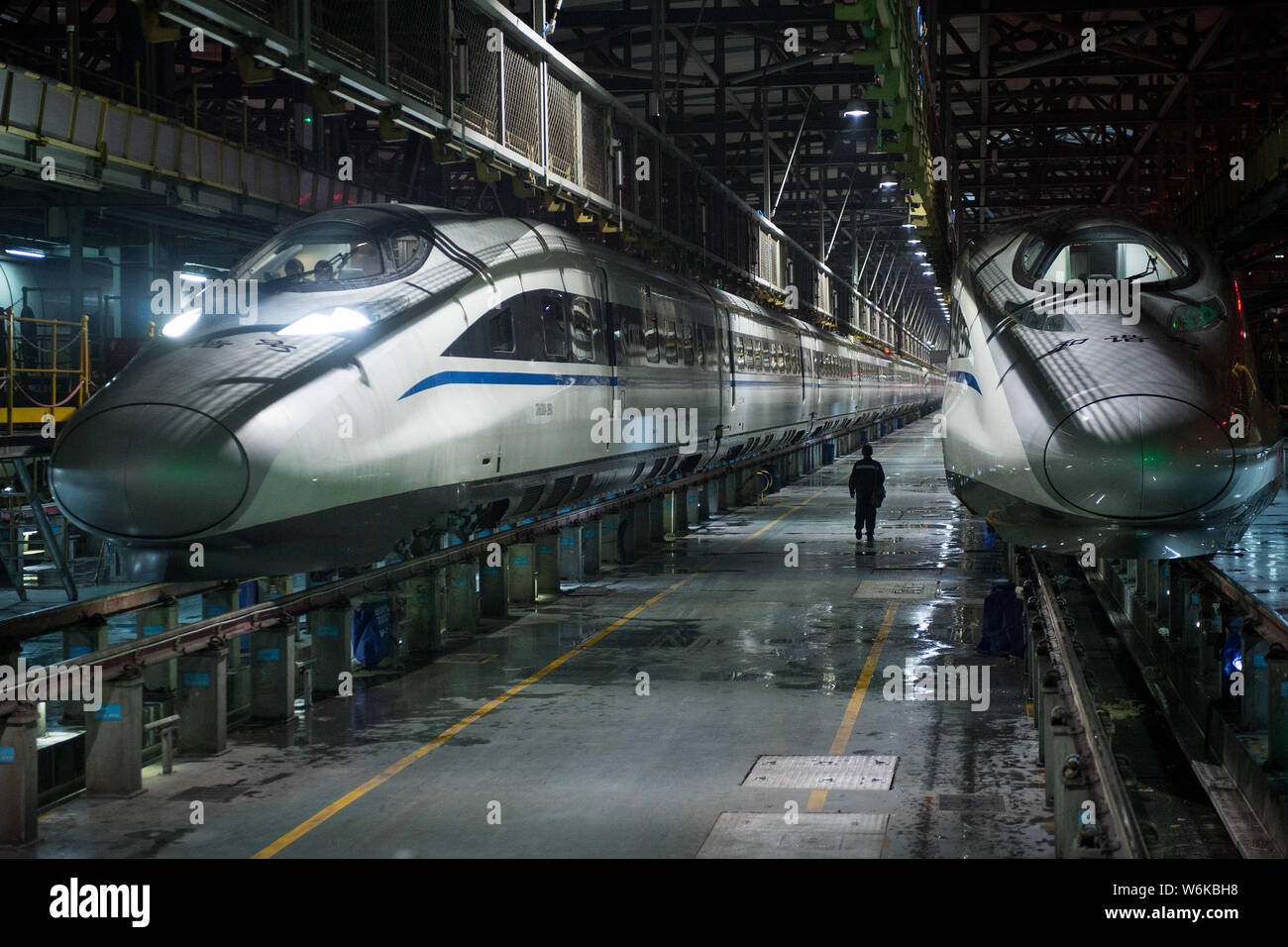 A Chinese worker walks past CRH (China Railway High-speed) bullet ...