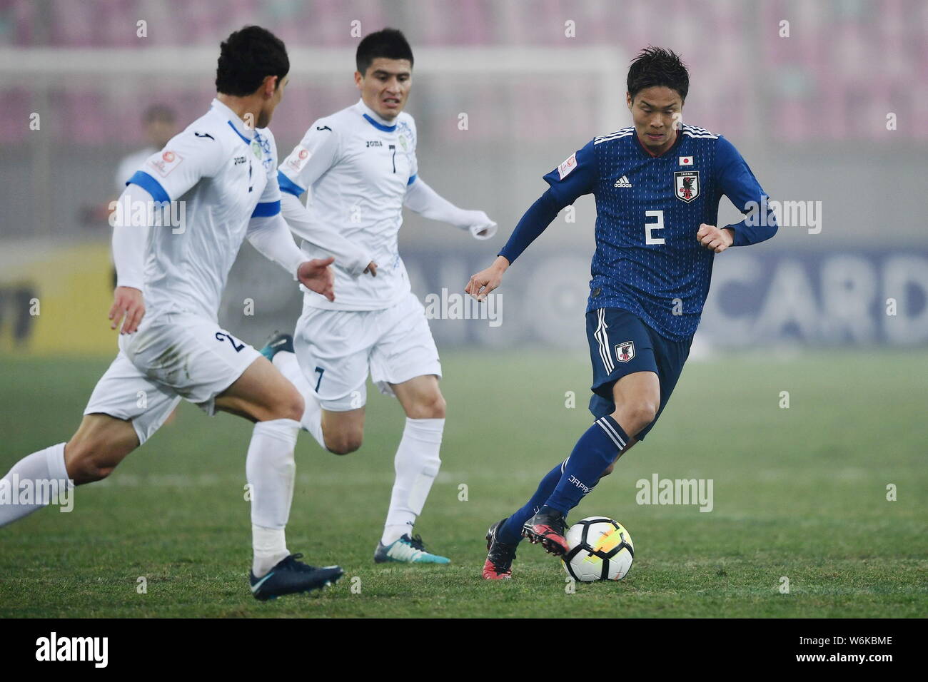 So Fujitani of Japan, right, dribbles against players of Uzbekistan in ...