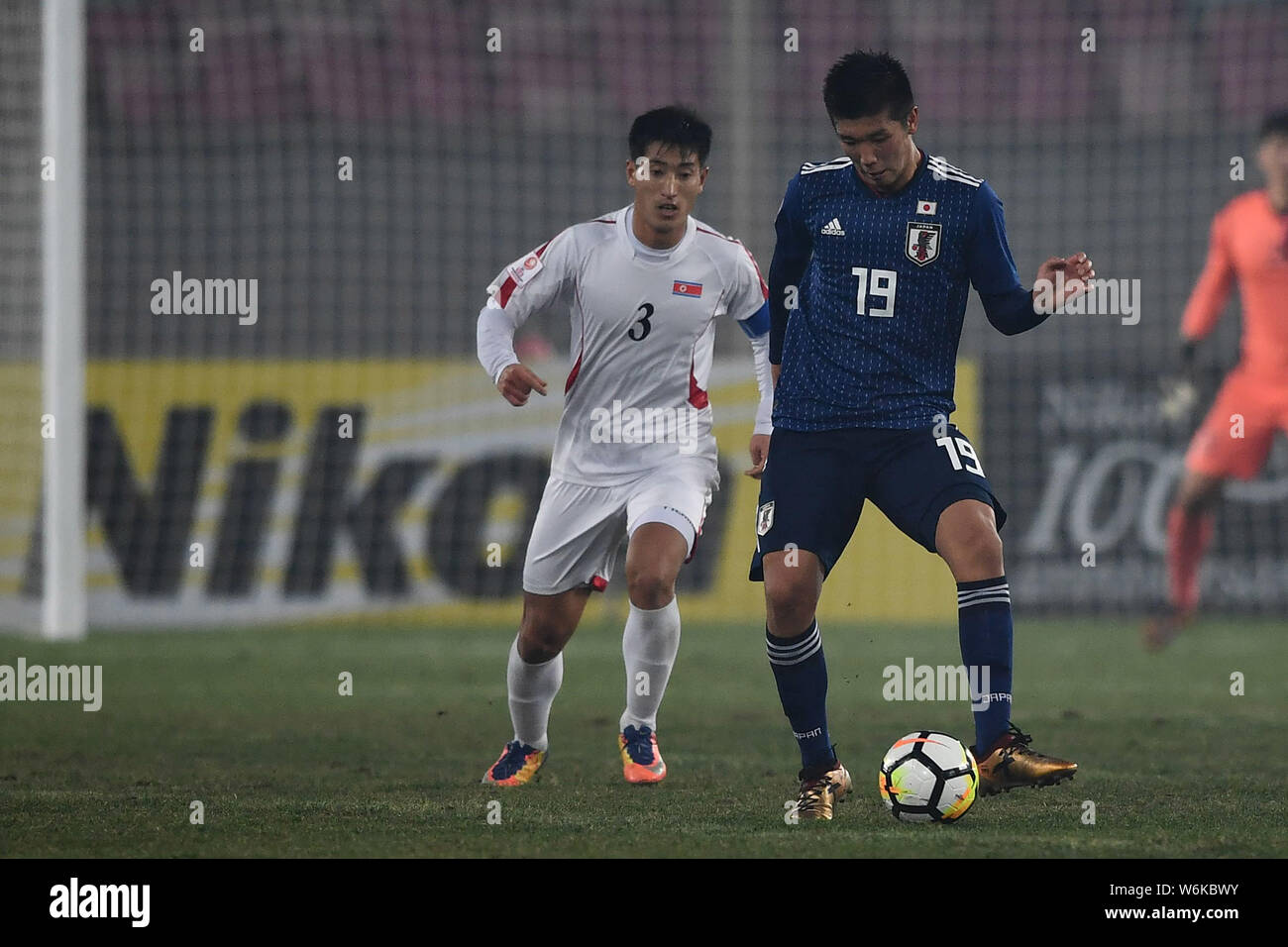 Ren Komatsu of Japan, right, challenges Song Kum-song of North Korea in their Group B match ...