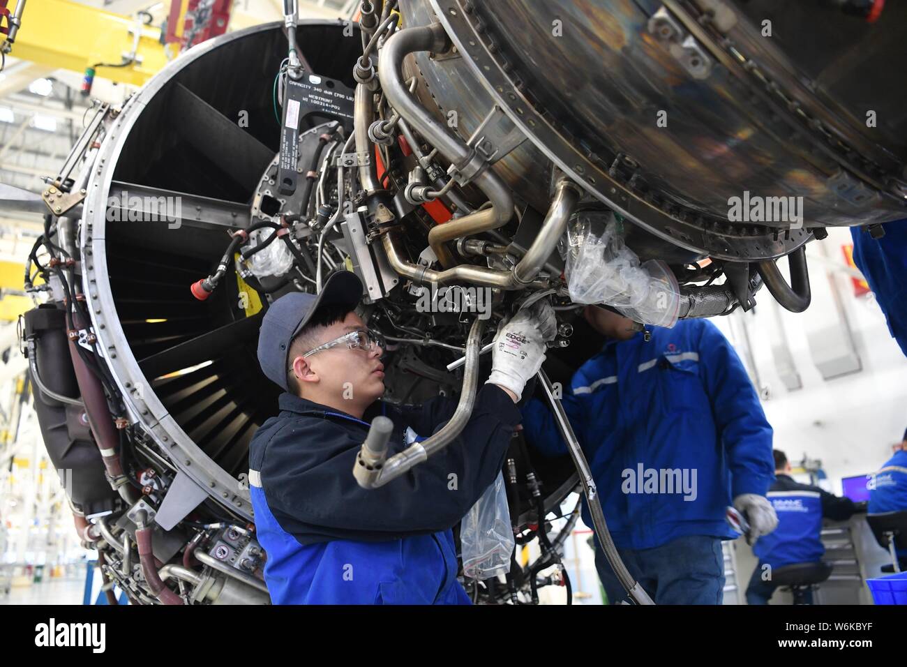 Chinese workers repair an aircraft engine at the Sichuan Services Aero ...