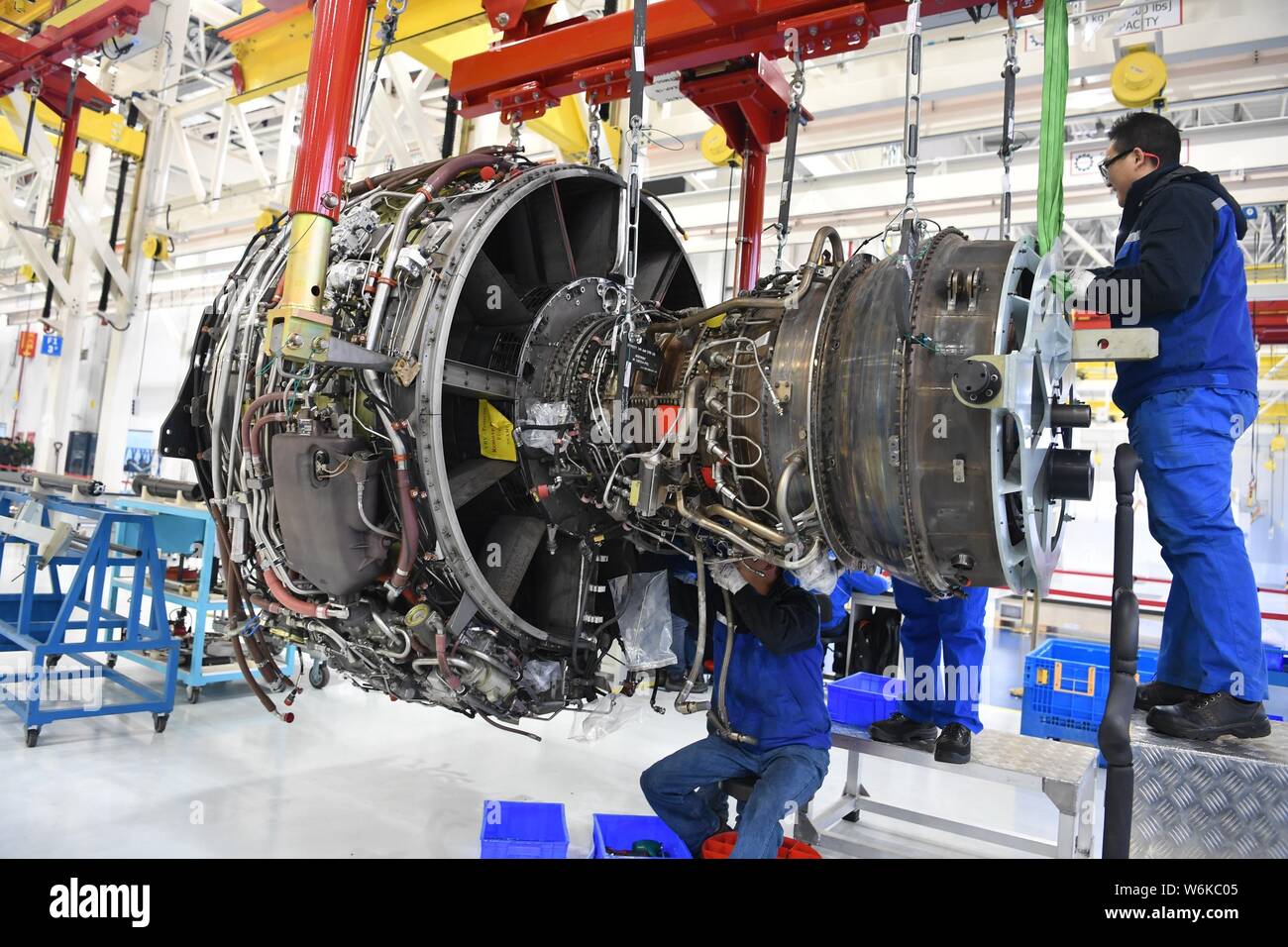 Chinese workers repair an aircraft engine at the Sichuan Services Aero ...