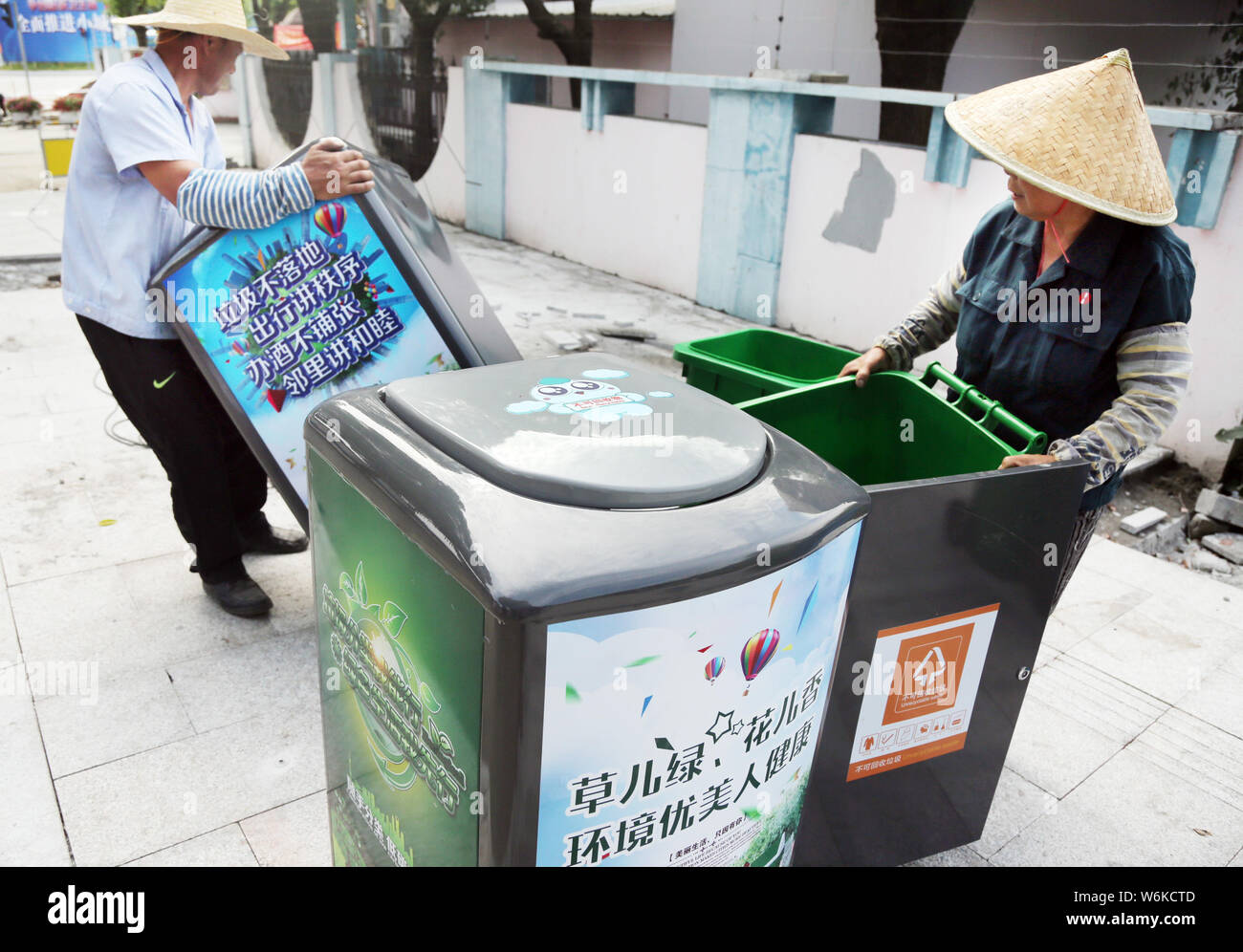 --FILE--Chinese workers install trash bins used for garbage sorting and ...
