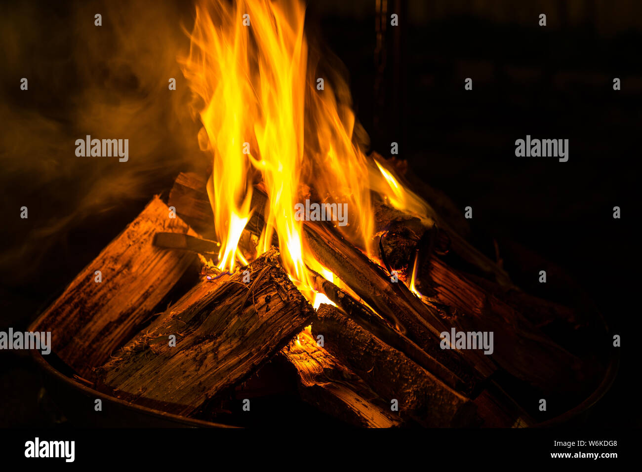 Wood billets burning with orange hot fire flames in night outdoor Stock ...