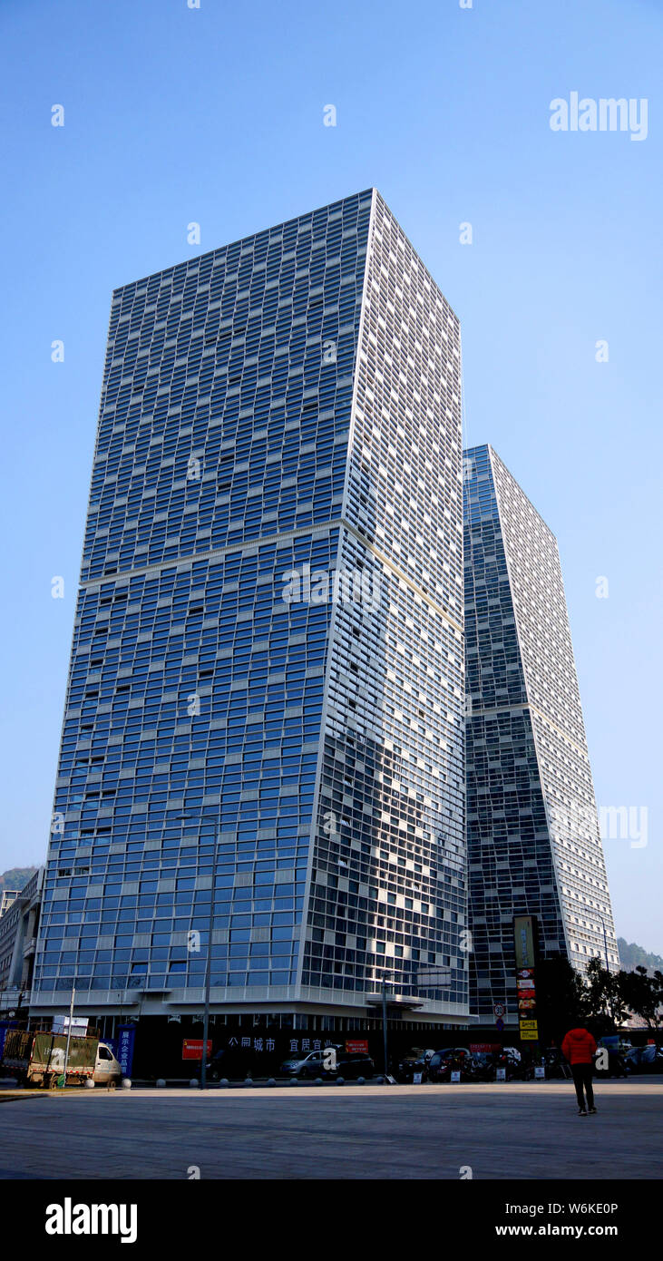 A local resident walks past the 101.3-meter-tall leaning buildings in ...