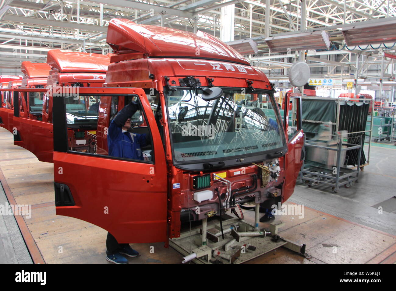 --FILE--A Chinese worker assembles trucks on the assembly line at an ...