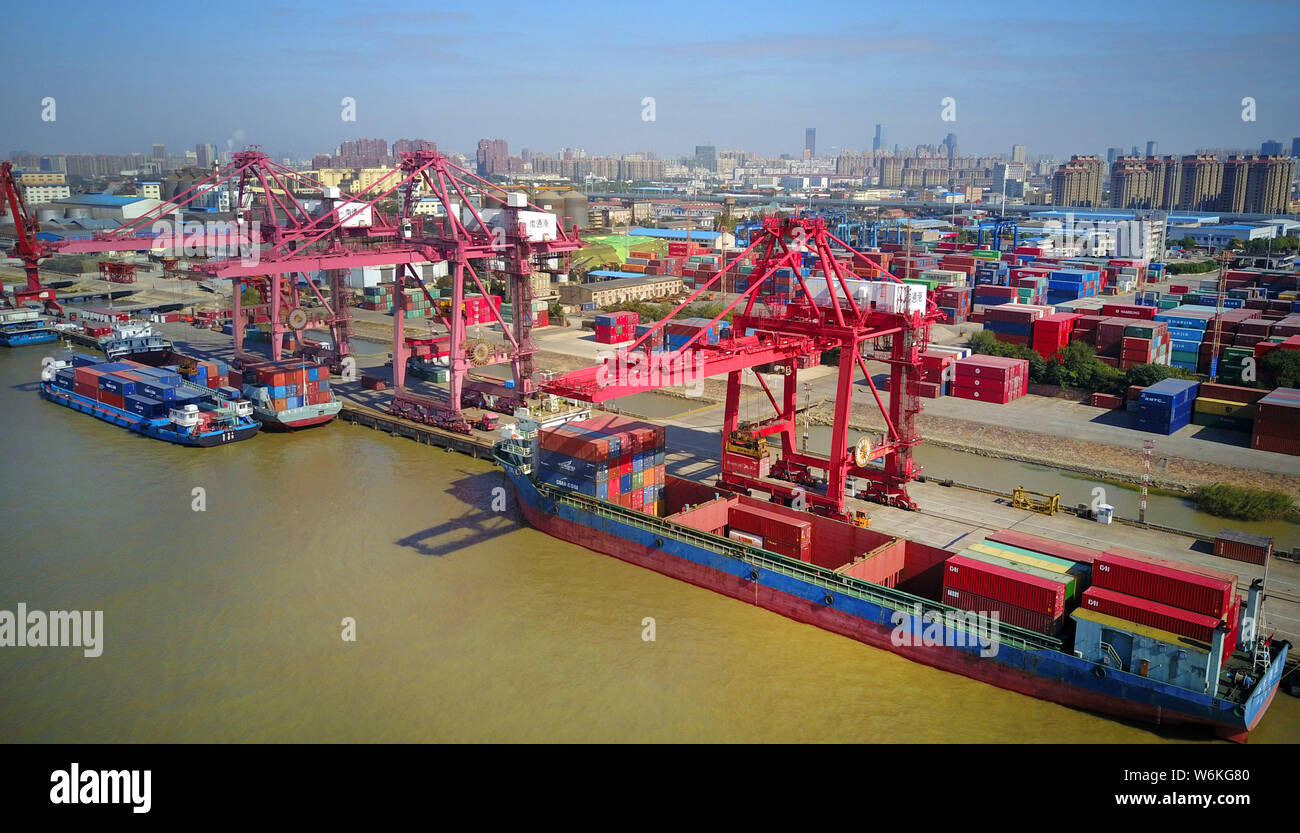 Cargo ships loaded with containers to be shipped abroad berth on a quay ...