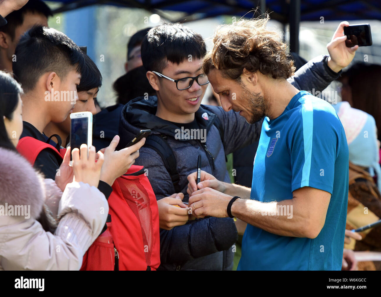 Uruguayan football player Diego Forlan, right, signs autographs for ...
