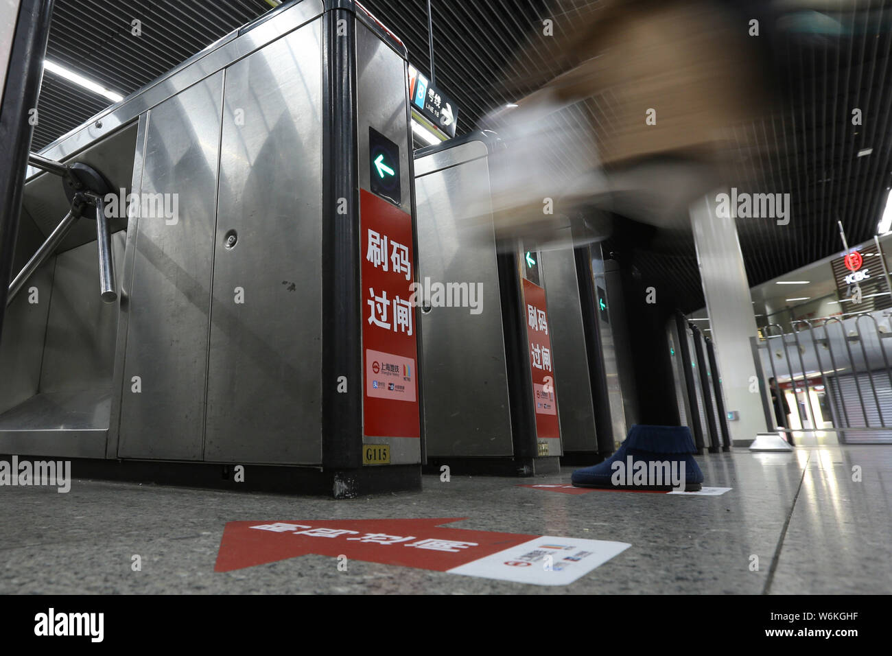 A passenger puts her smartphone above a turnstile to have the QR code ...