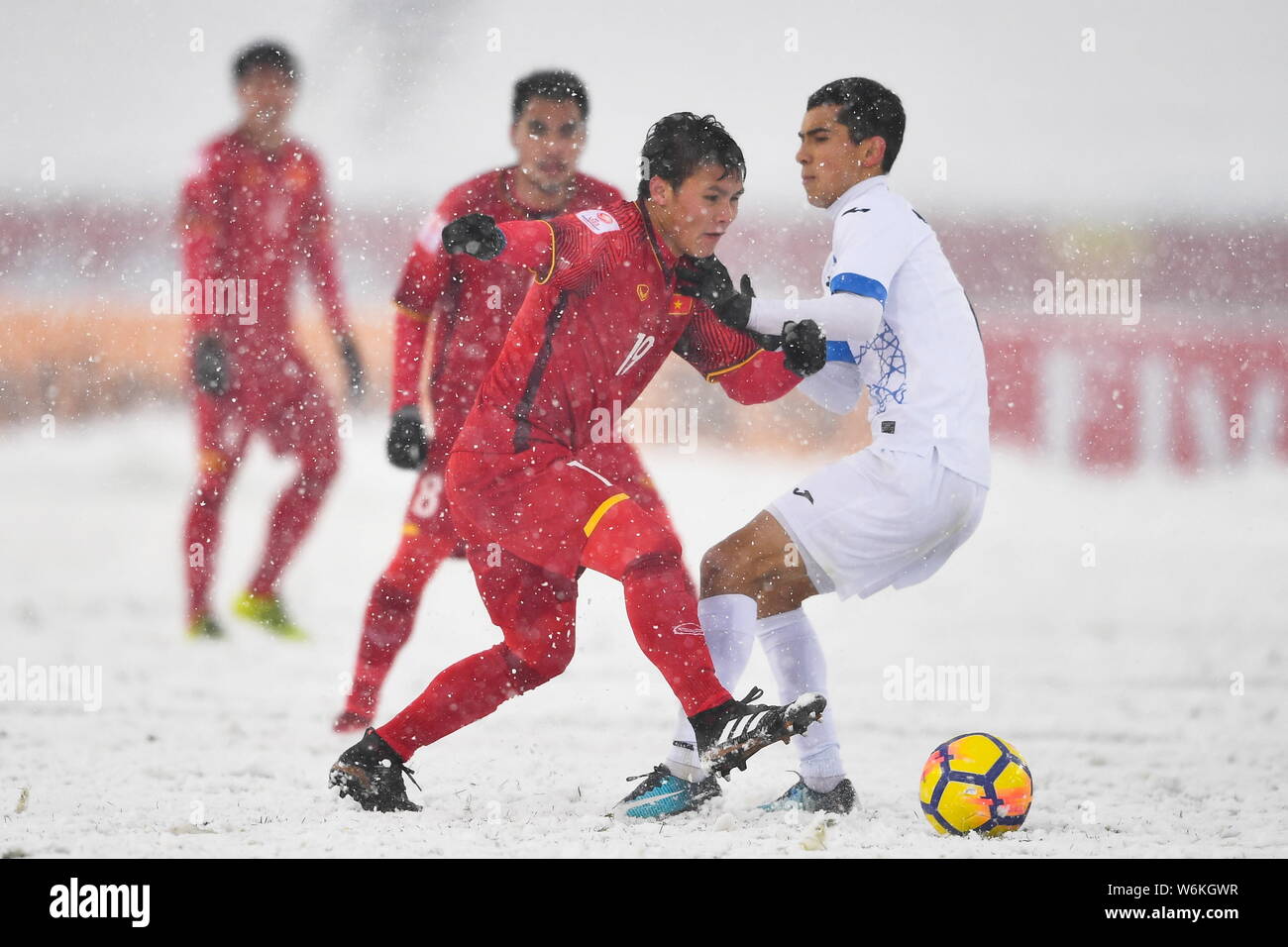 Nguyen Quang Hai, left, of Vietnam kicks the ball to make a pass against a player of Uzbekistan ...