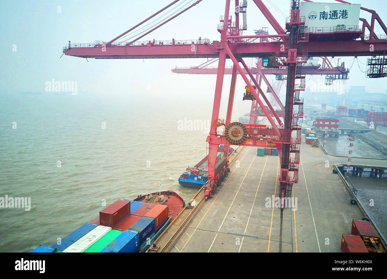 Cargo ships loaded with containers to be shipped abroad berth on a quay ...