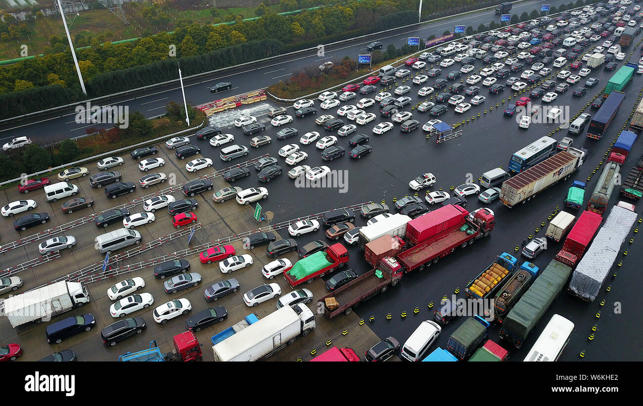 In this aerial view, masses of vehicles queue up to pass through a toll ...