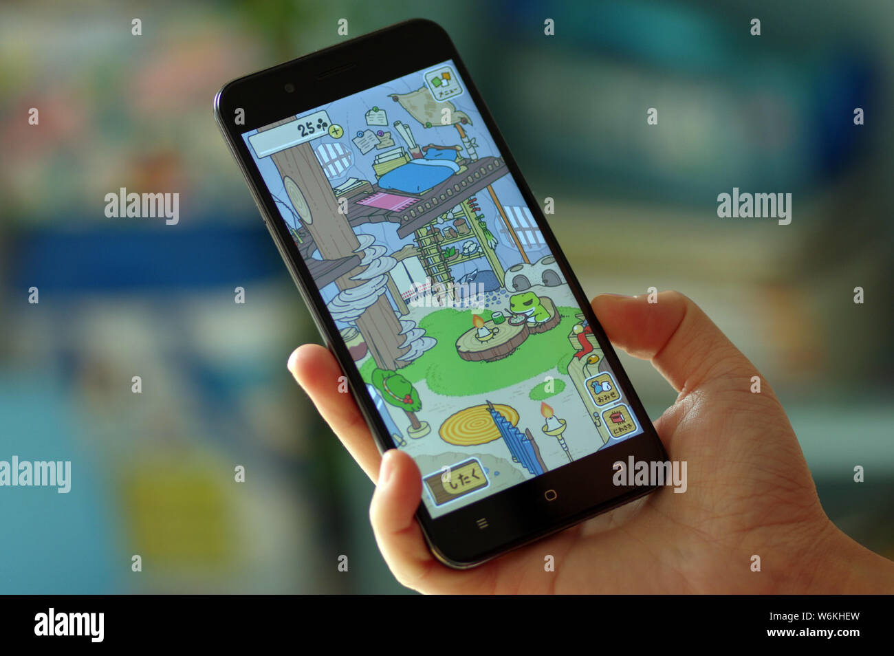 --FILE--A Chinese player "raises" a frog as she plays mobile game "Tabi ...