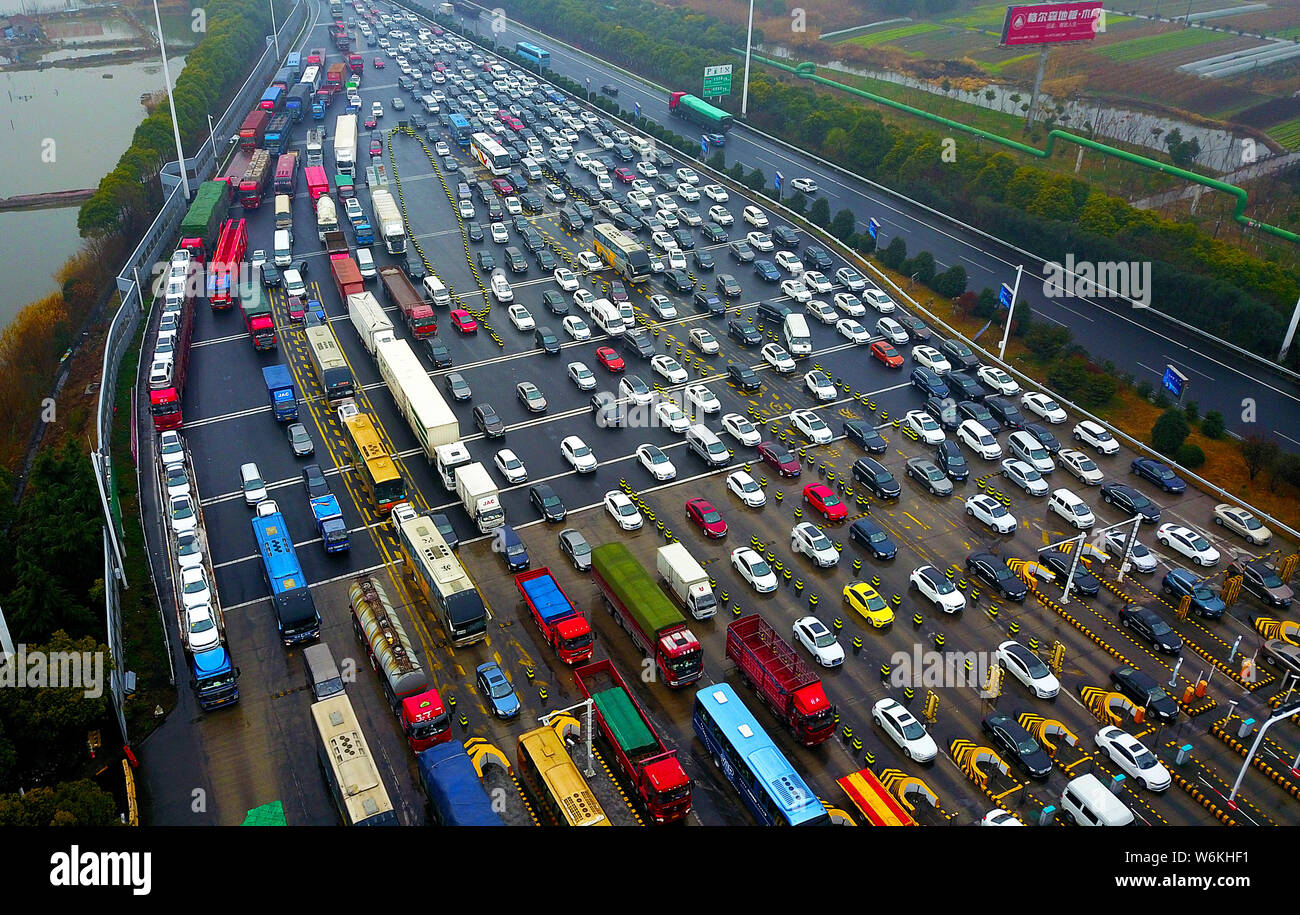 In this aerial view, masses of vehicles queue up to pass through a toll ...