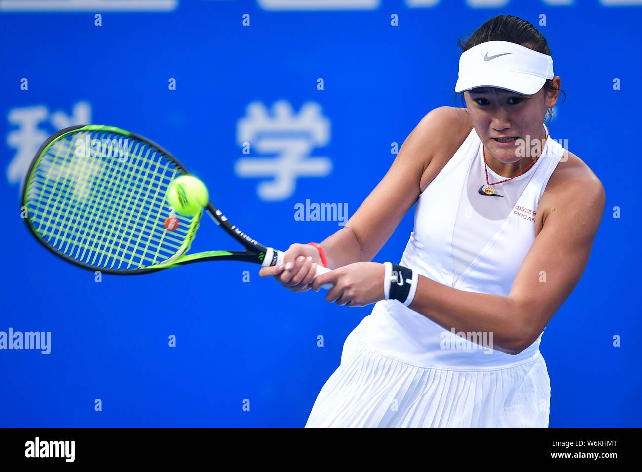 Wang Xiyu of China returns a shot to Timea Babos of Hungary in their ...