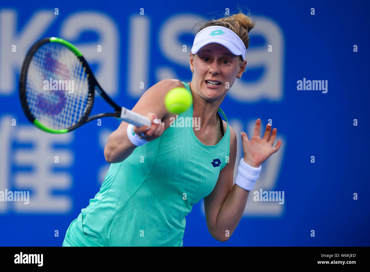 Alison Riske of the United States returns a shot to Wang Qiang of China ...