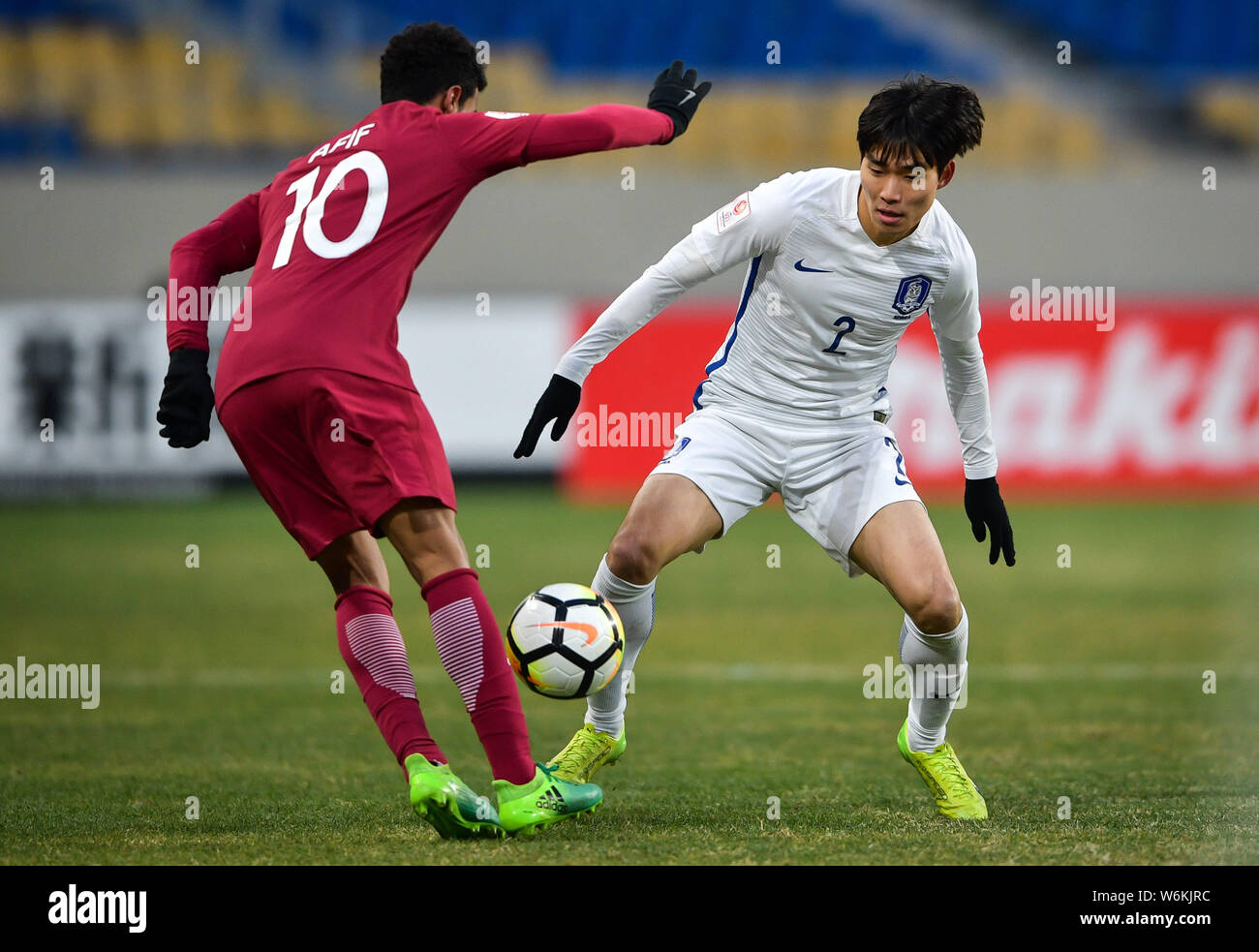 Park Jaewoo, right, of South Korea kicks the ball to make a pass against Akram Afif of Qatar in ...
