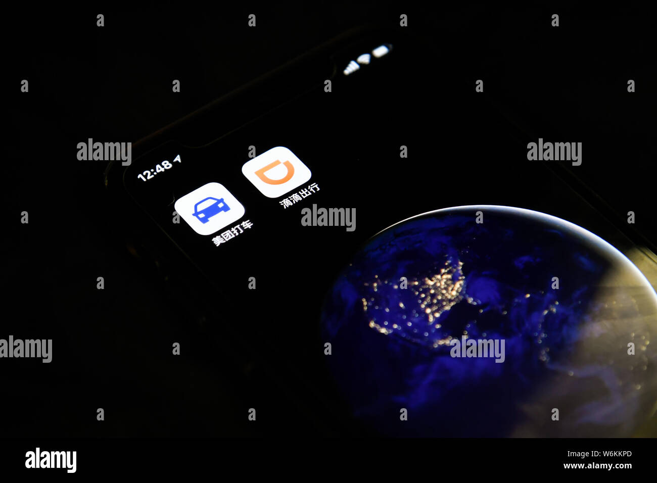 A mobile phone user shows the icons of the taxi-hailing and car-service ...