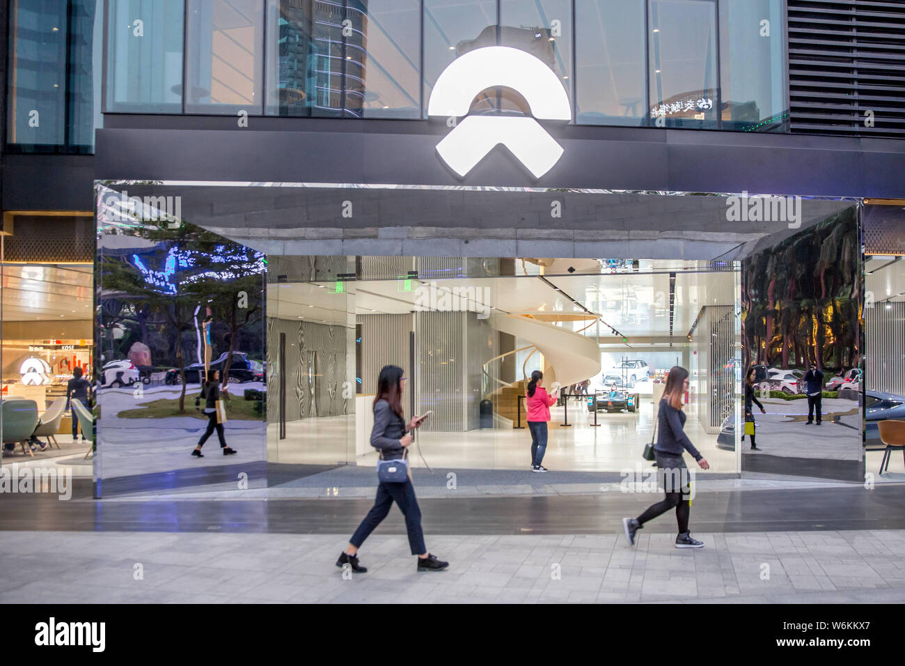 Pedestrians walk past the fourth Nio's user center, NIO House, in ...