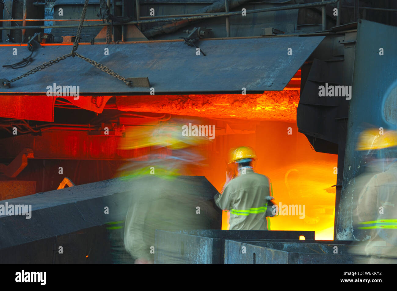 --FILE--Chinese workers survey the production of steel next to a ...