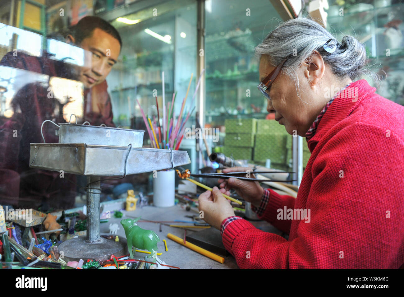 --FILE--Chinese Liuli handicraft master Xing Lanxiang makes a Liuli ...