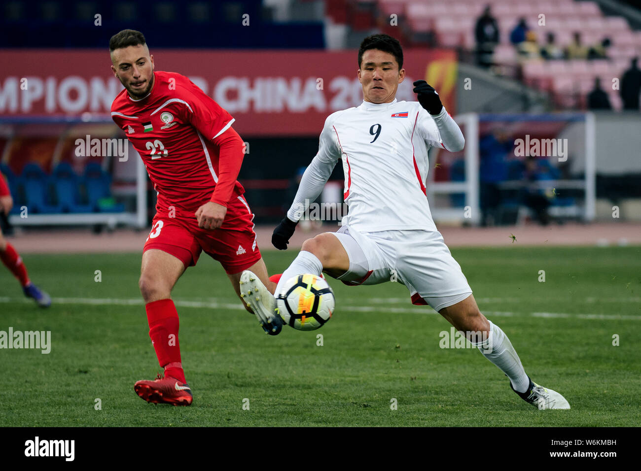 Kim Yu Song, right, of North Korea kicks the ball to make a pass ...