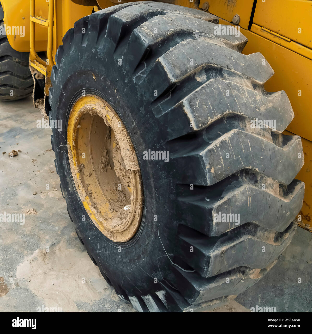 frame Close up view of the black rubber wheel of a yellow construction ...