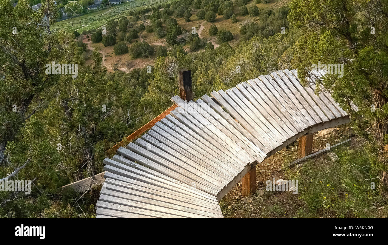 Panorama Close up of a wooden bridge amid trees and curving over the ...