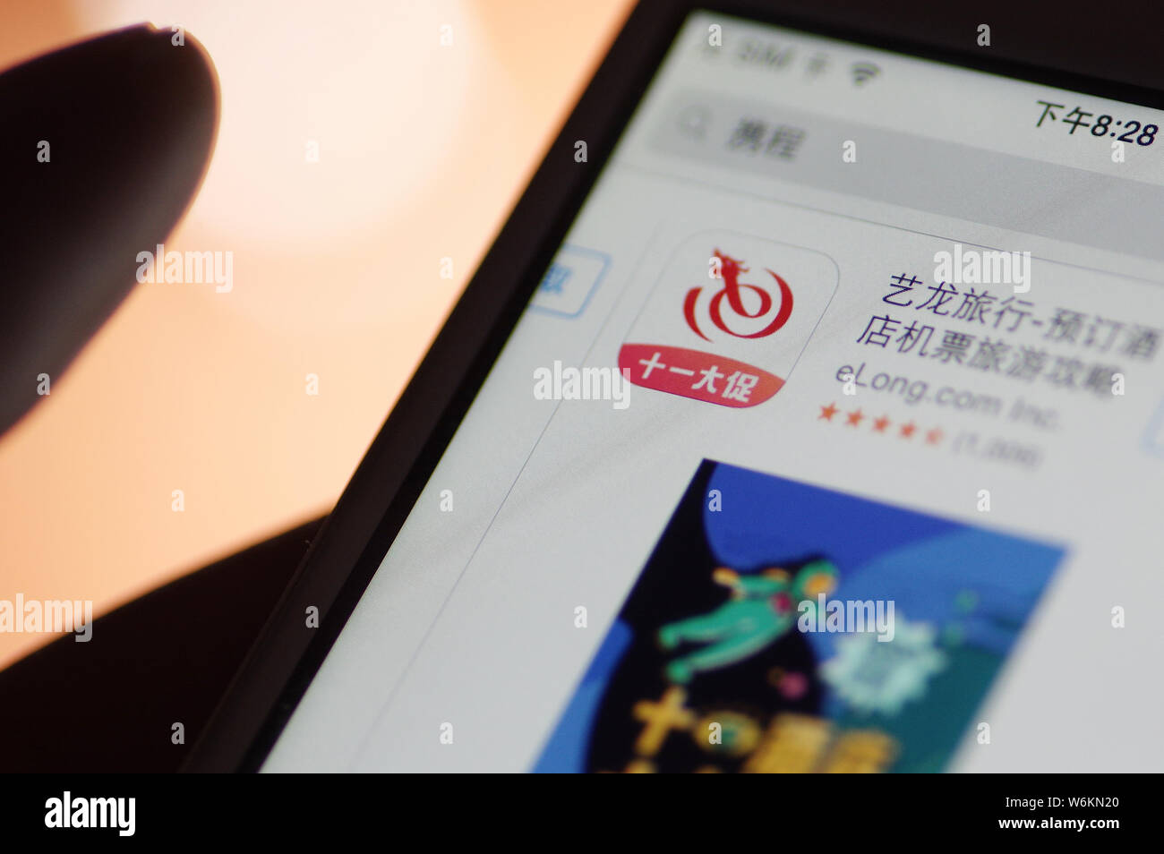 --FILE--A mobile phone user shows an icon of the mobile app of travel ...