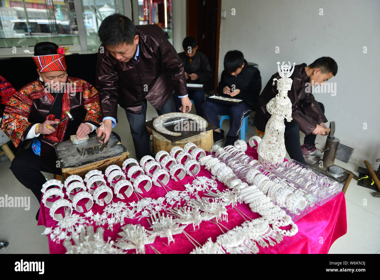 Chinese craftsmen make traditional silver decorations of Chinese ethnic ...