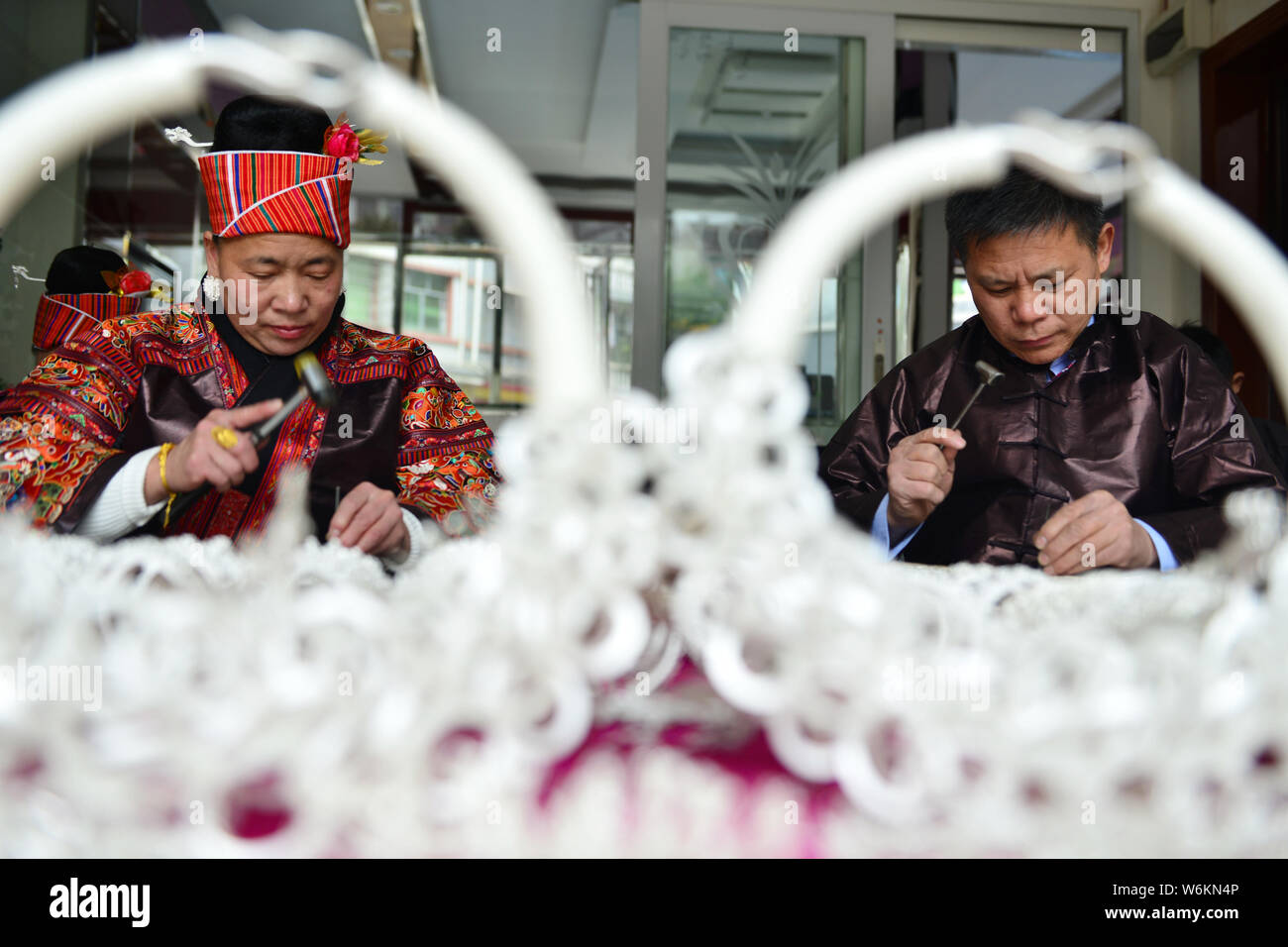 Chinese craftsmen make traditional silver decorations of Chinese ethnic ...